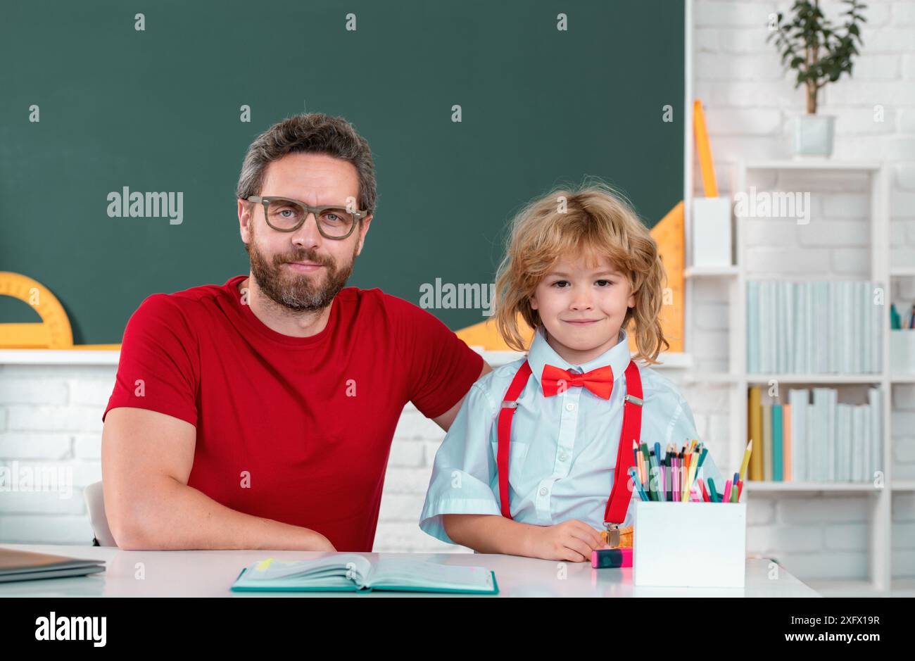 First day at school. Cute little boy from elementary school and tutor ...