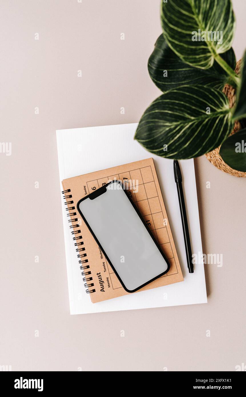 Blank path screen mobile phone with mockup on various notepads on beige ...