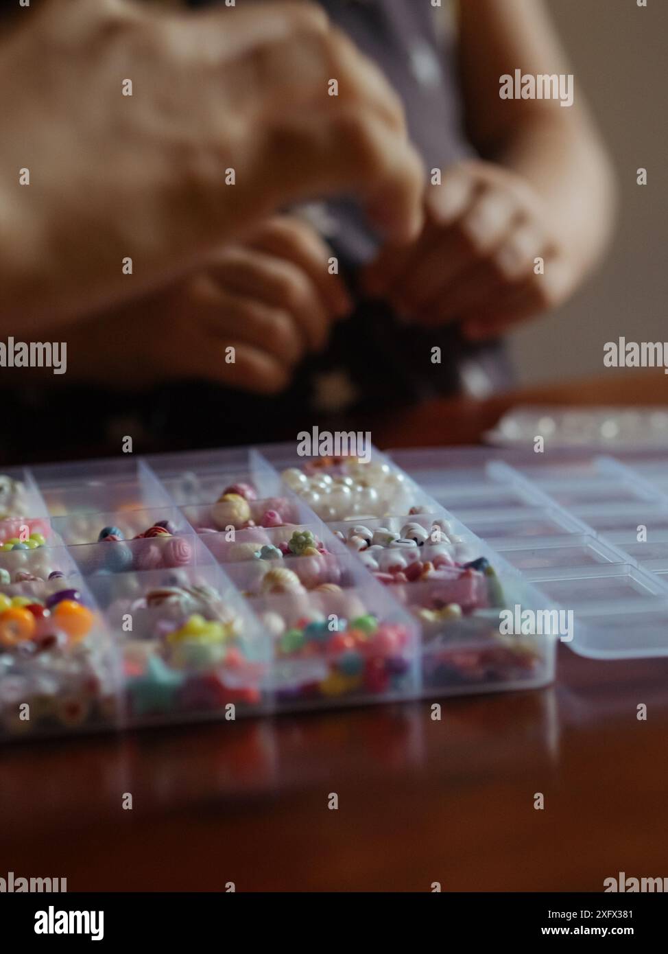 Mom and daughter creating bead jewelry: A vertical close-up shot ...