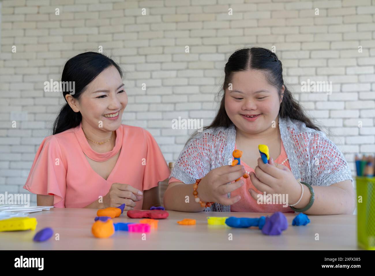 A mother is lovingly caring for her daughter with Down syndrome at home ...