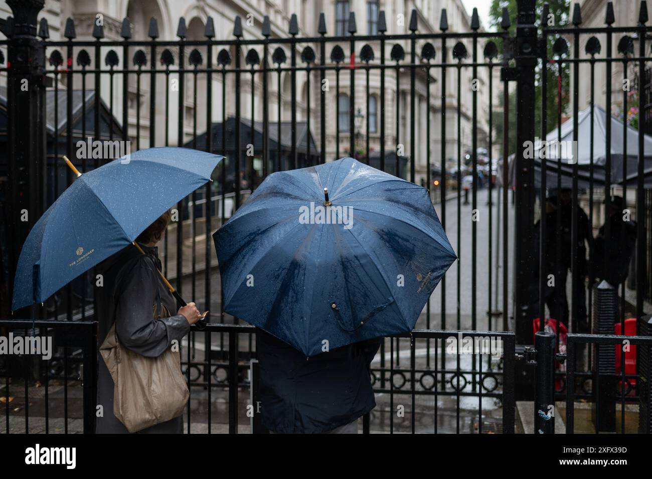 London, UK. 5th July 2024. Despite the rain people gather outside 10 ...