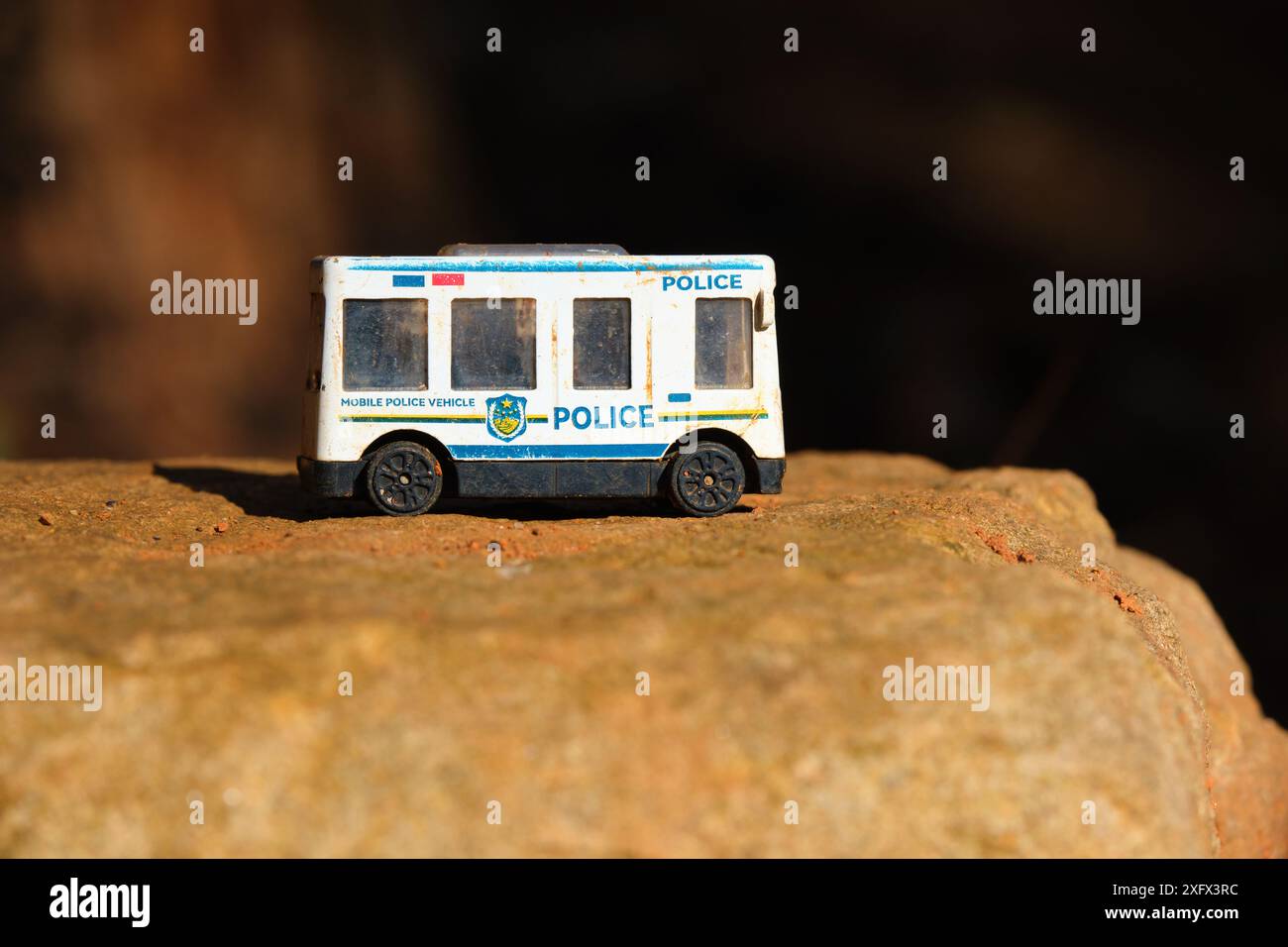 A muddy toy model mobile police vehicle or van on rough terrain Stock ...