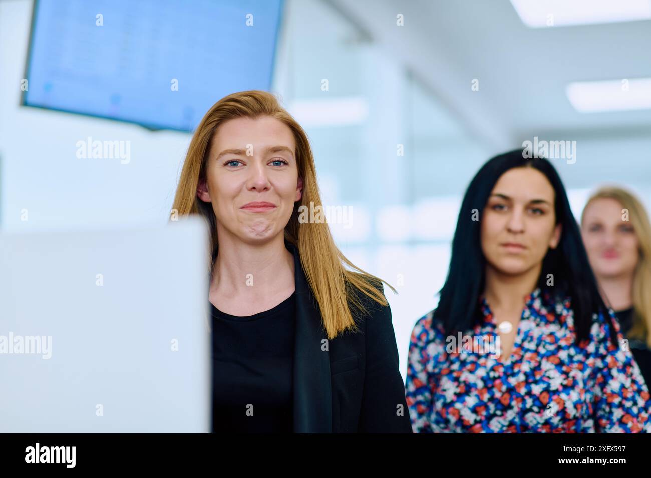 Confident businesswomen stride through the office hallway, deep in ...