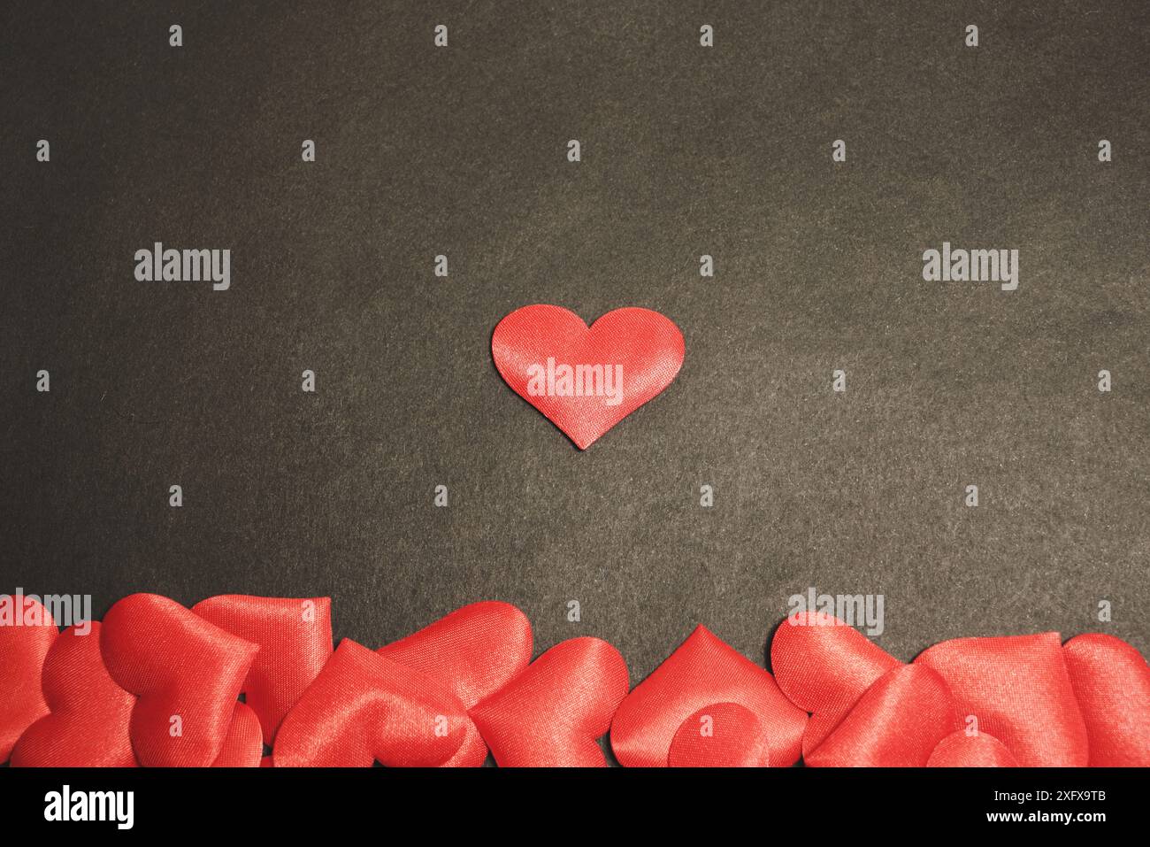 Horizontal photo of a single red heart centered in a dark background ...