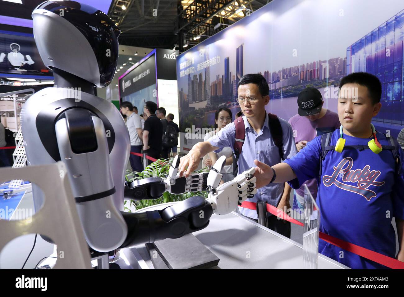 Shanghai, China. 5th July, 2024. Visitors touch the bionic hands of a robot during the 2024 ...