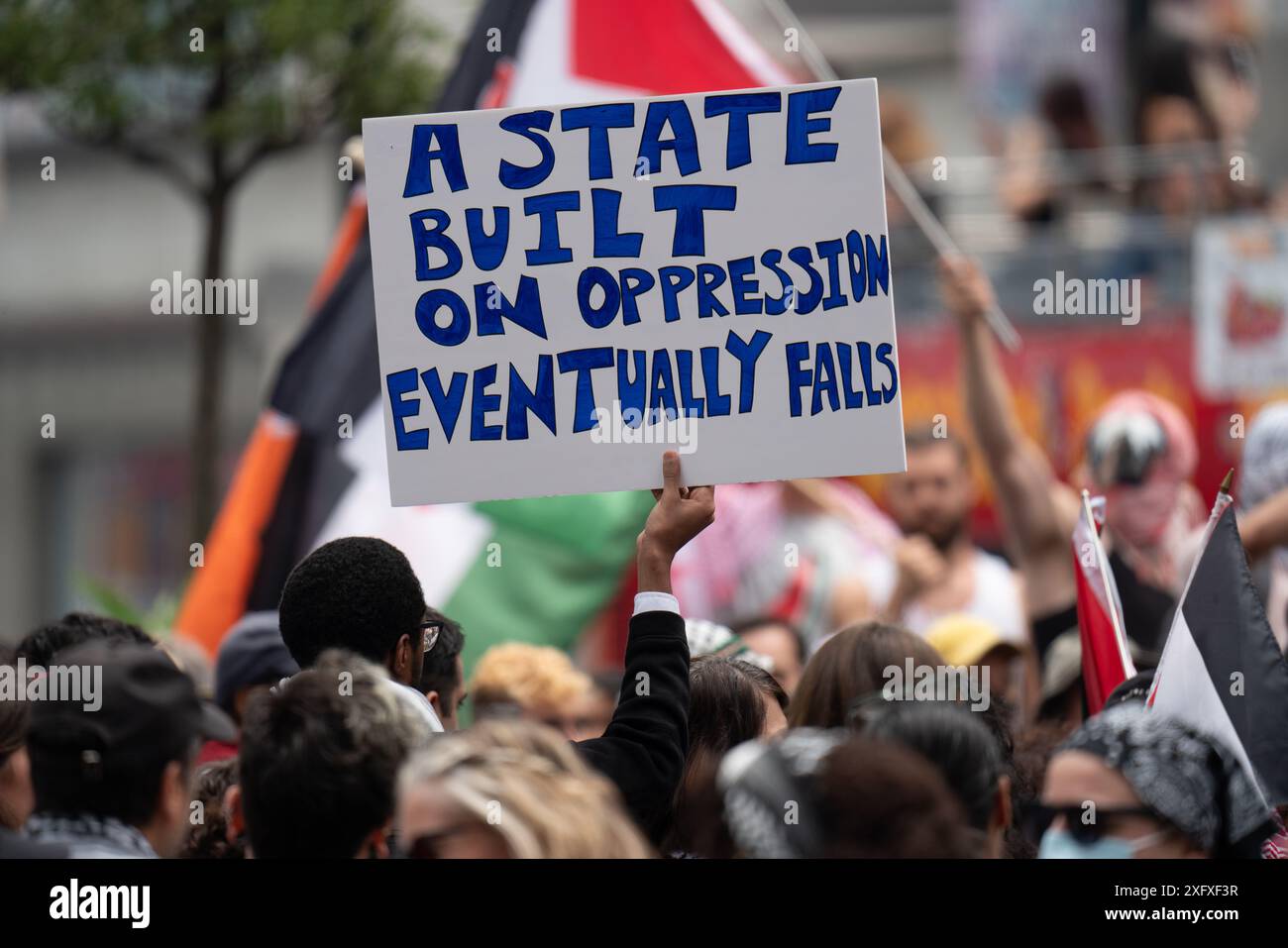 Protesters at the All Out For Gaza protest marching with picket signs ...