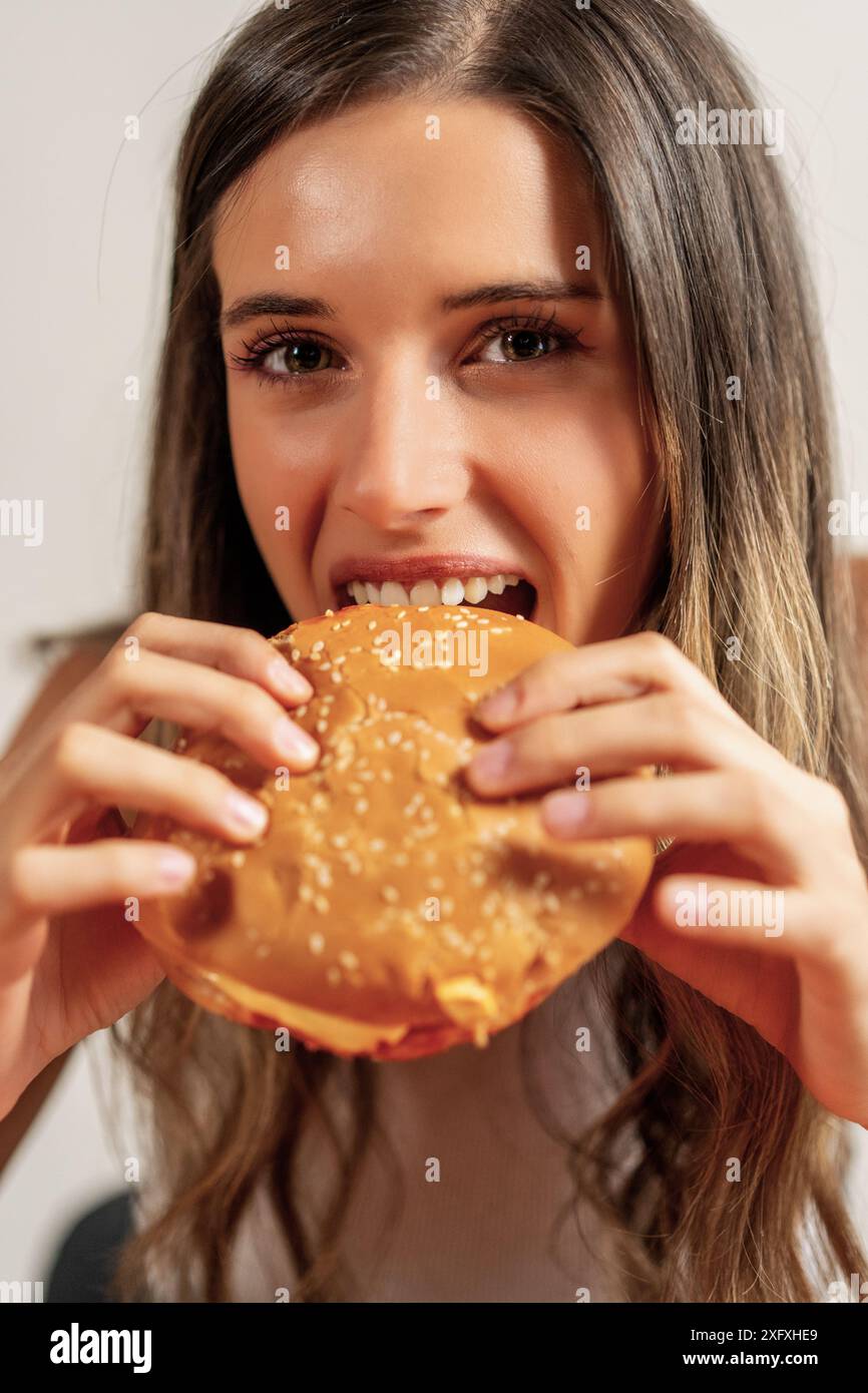 Woman eating hamburger - enjoying fast food - delicious meal, smiling ...