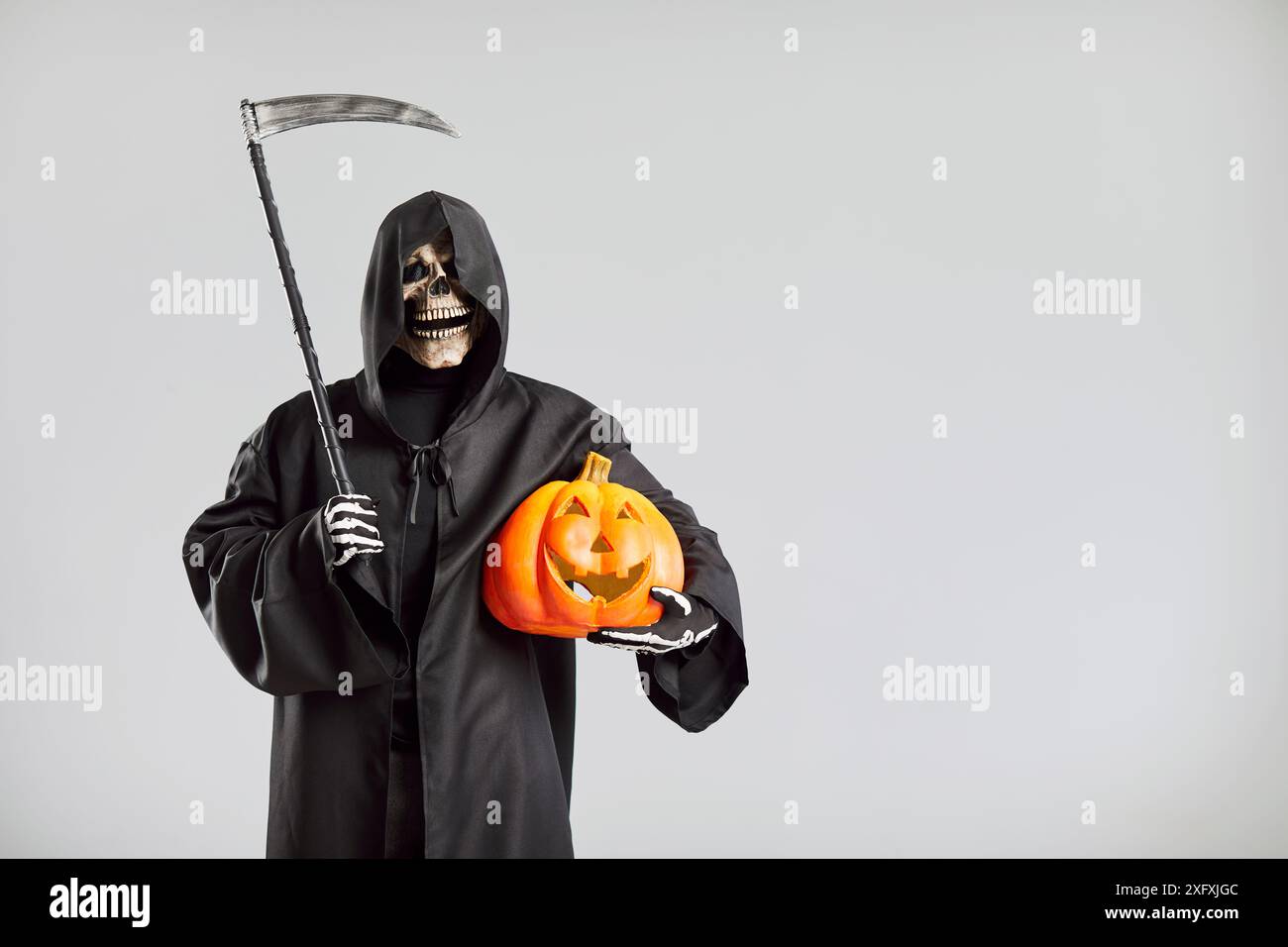 Man in grim reaper death costume isolated on studio gray background ...