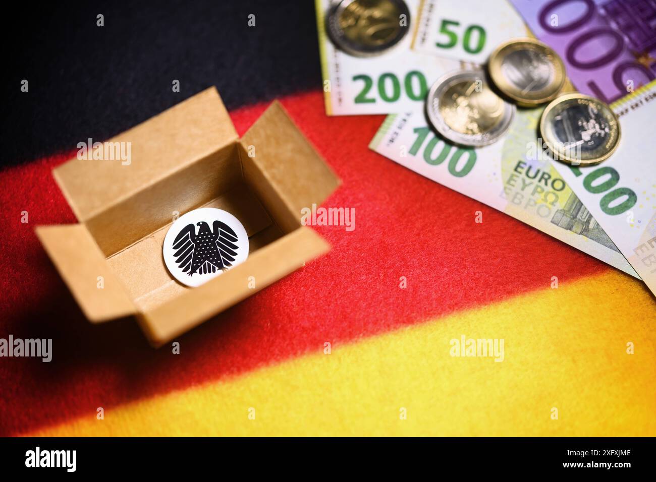 Paket mit Bundesadler und Geldscheine auf Deutschlandfahne ...