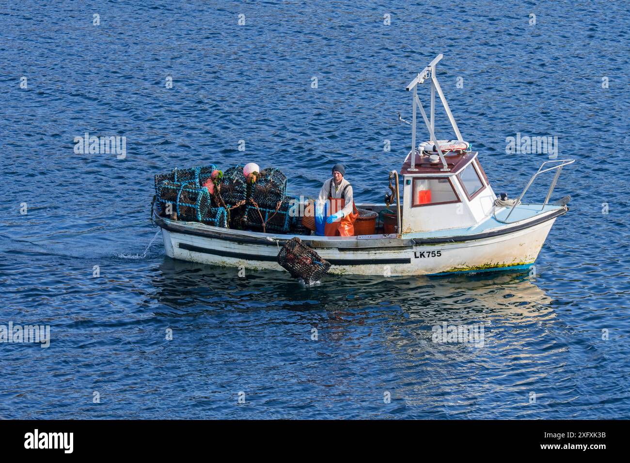 Fisherman in small fishing boat dropping / shooting lobster traps in ...