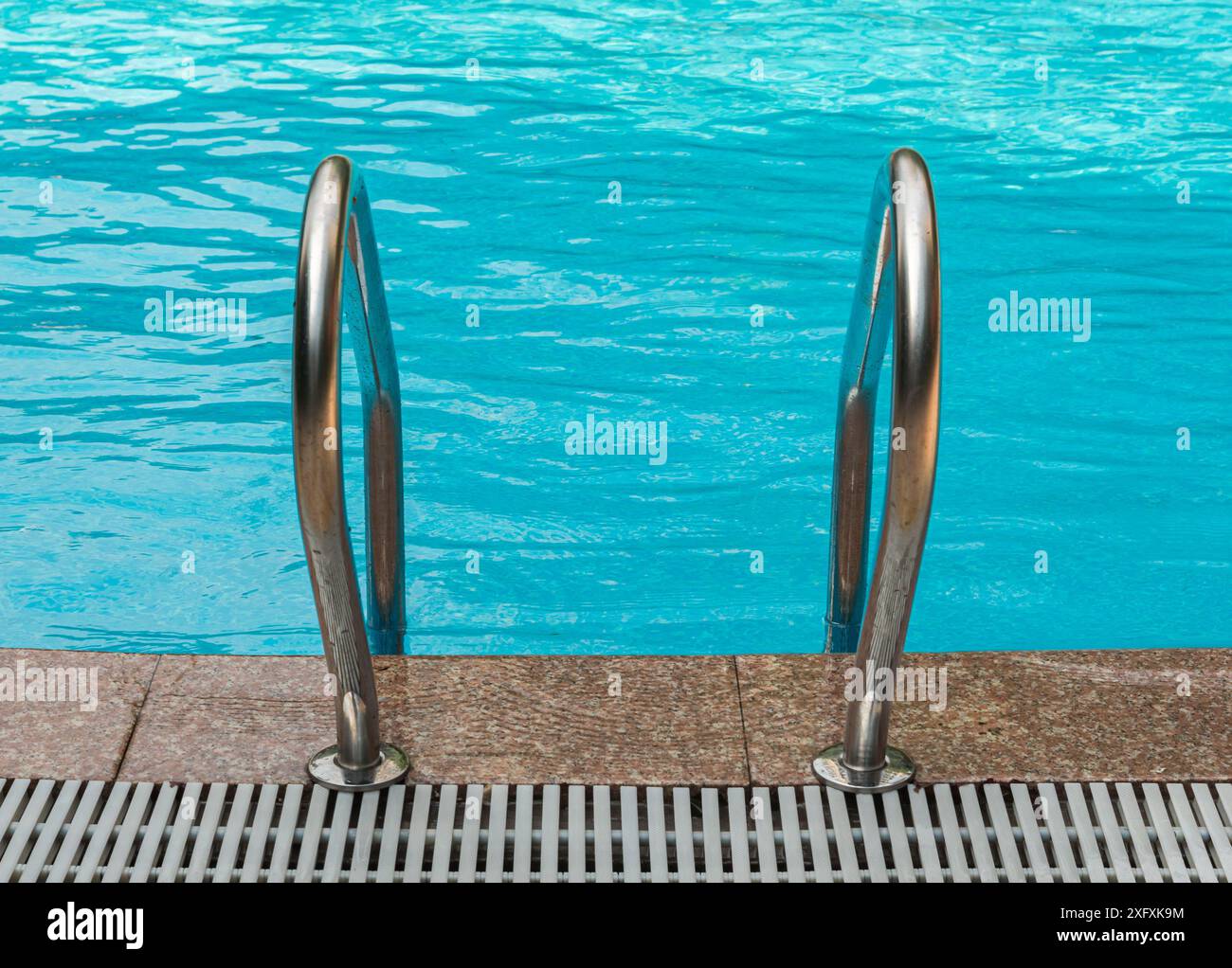 A close-up view of the stainless steel handrails of a swimming pool ...
