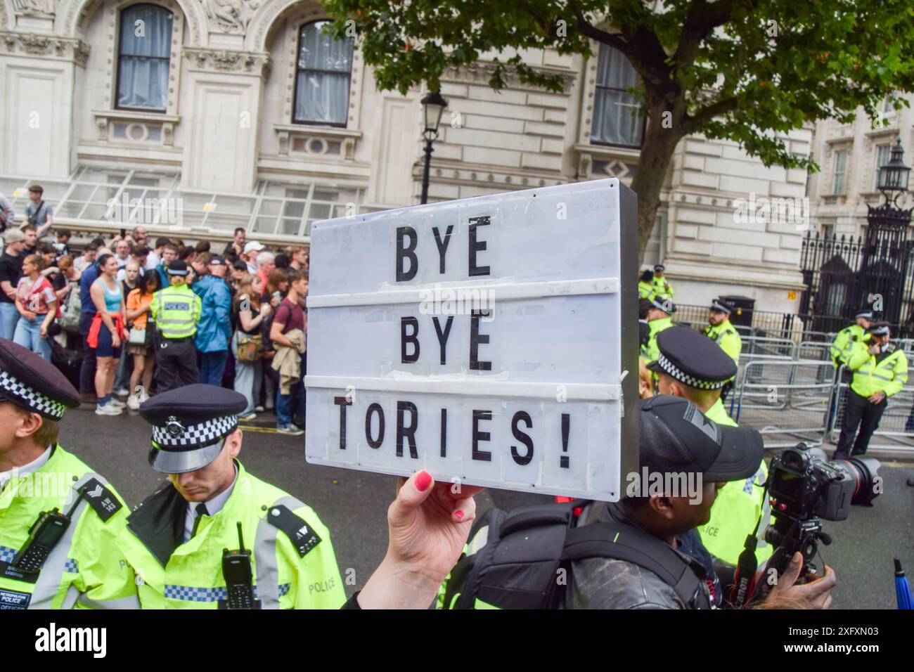 London, UK. 05th July, 2024. An activist holds an anti-Tory sign as ...