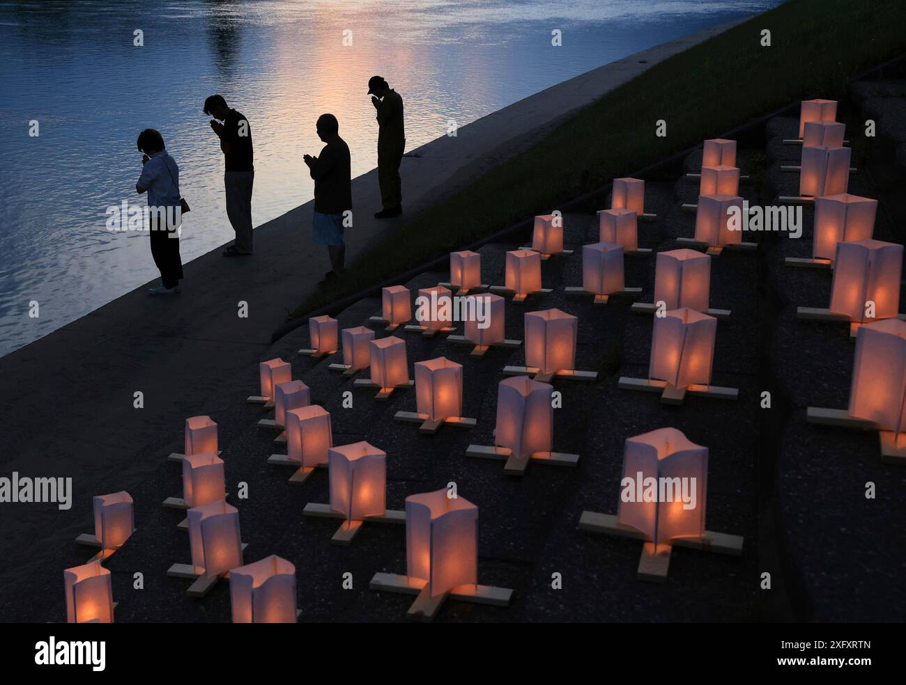 People light up lanterns to offer a silent prayer for the victims of ...