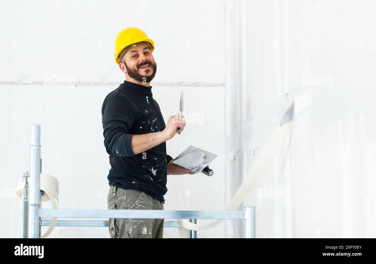 Interior construction, worker plastering gypsum board wall Stock Photo ...