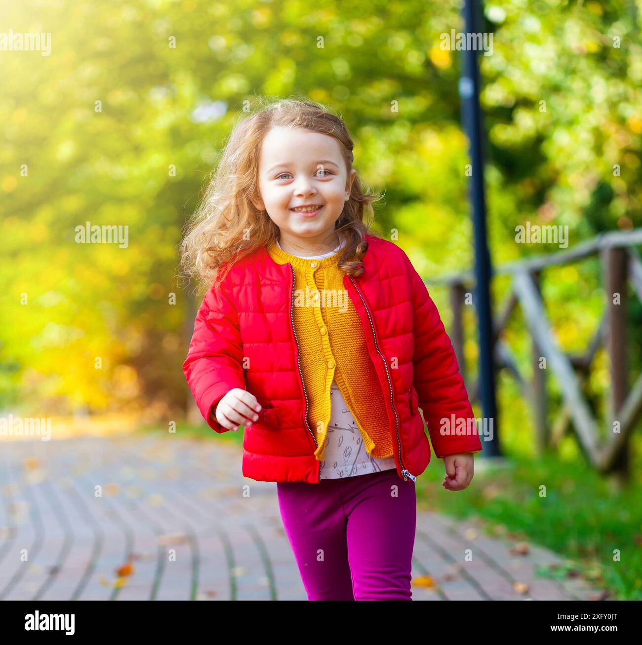 Adorable little girl walking in park on a fall day. Female toddler with ...