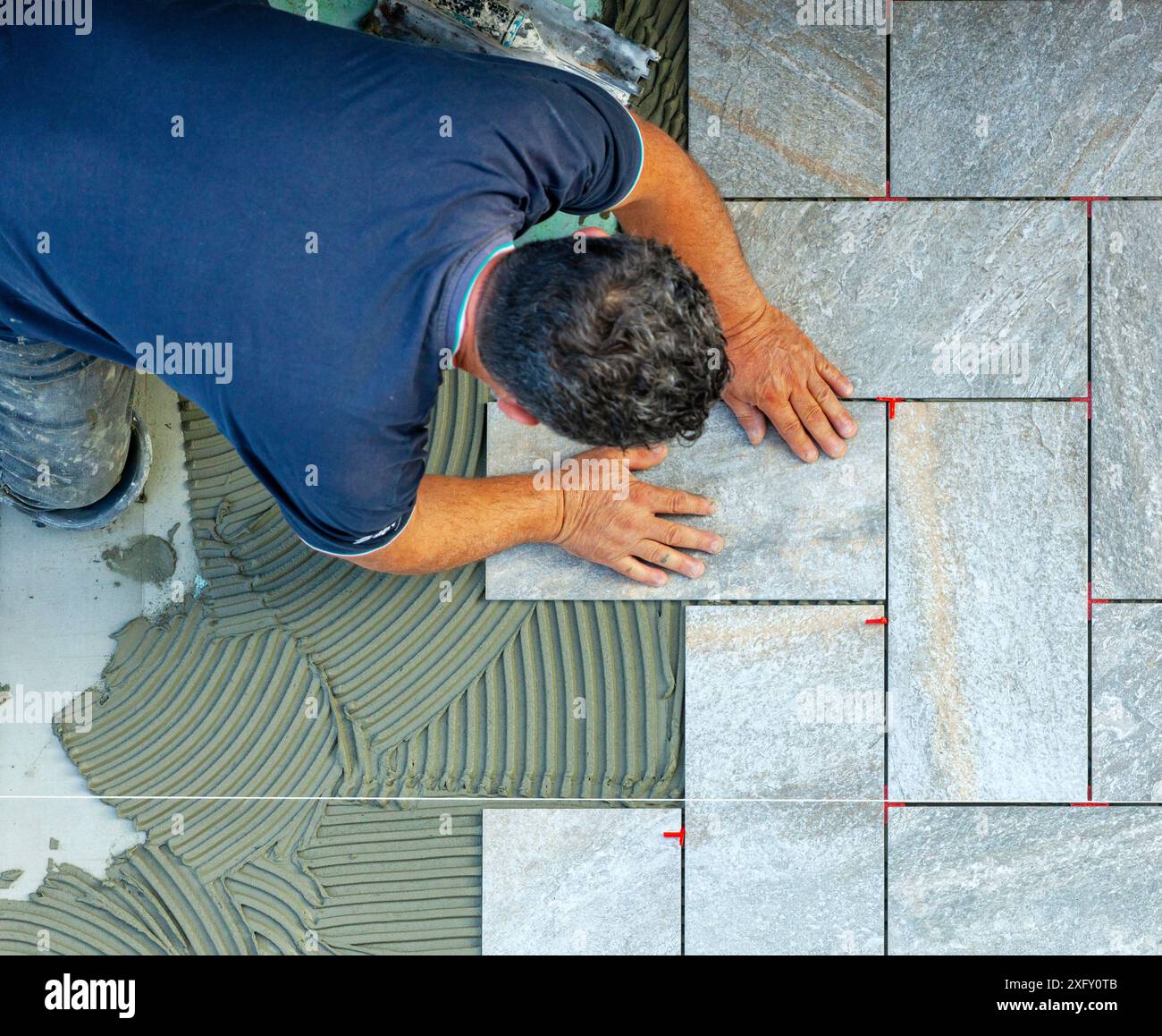 Tiler carefully lays every single tile with the help of a wire to ...