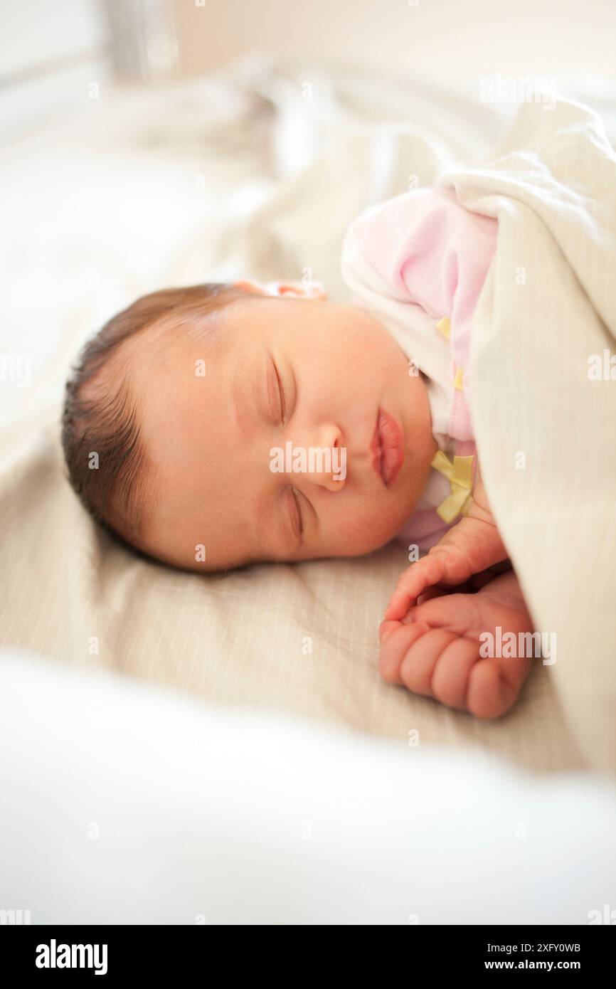 Newborn baby girl sleeping in bed Stock Photo - Alamy