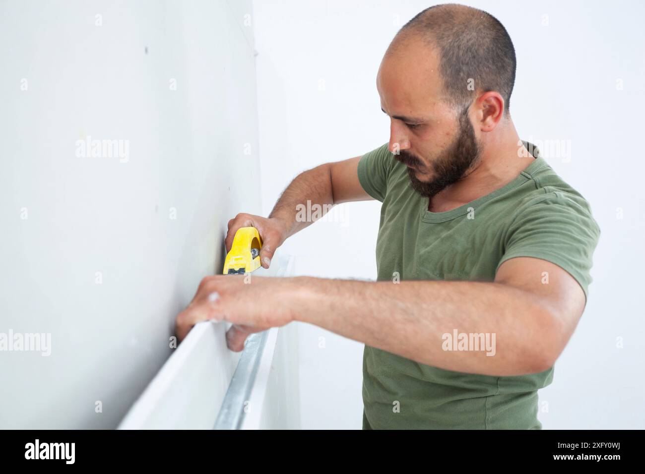 Worker building plasterboard wall working with cutting tools hi-res ...