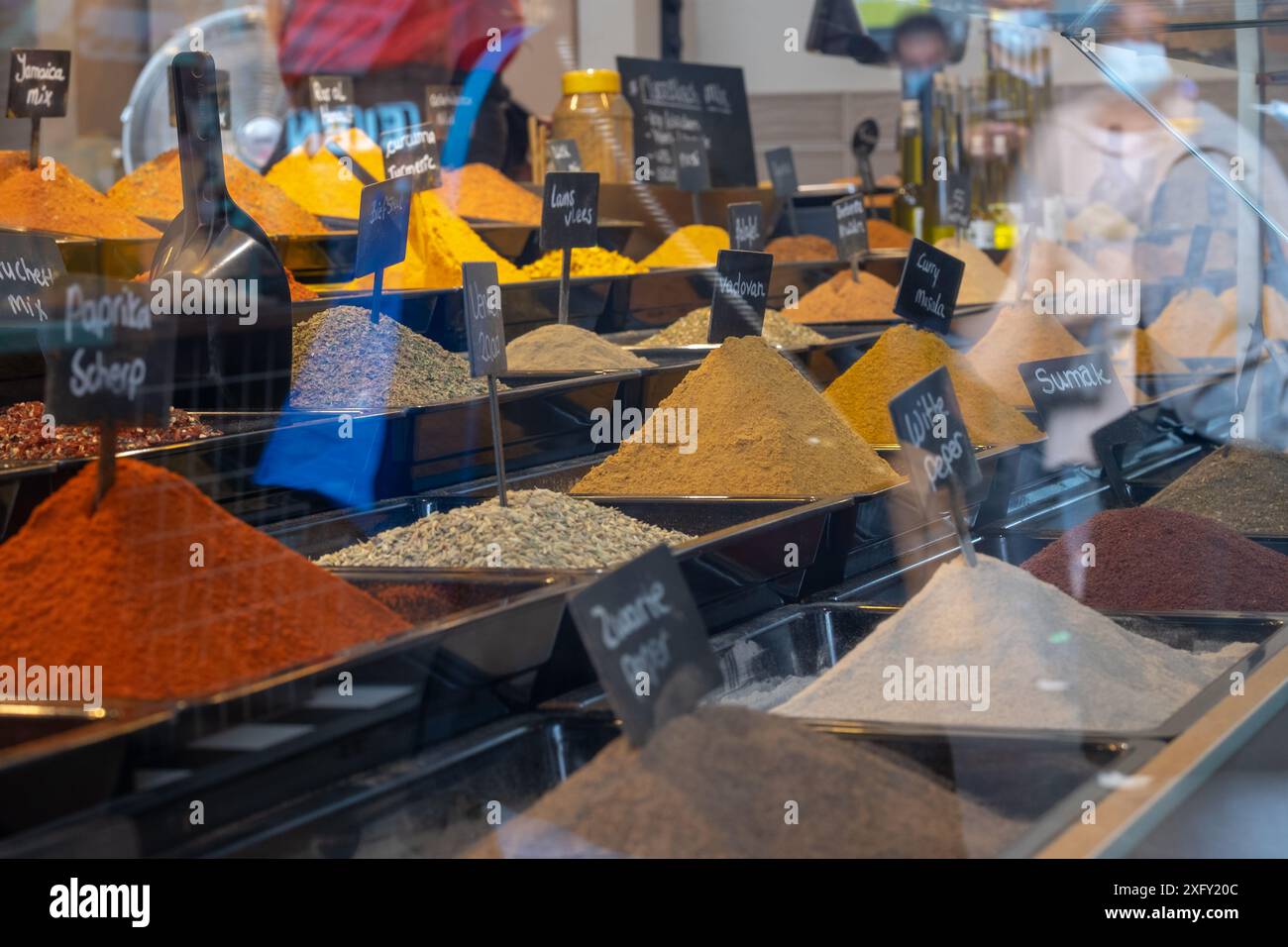 A variety of spices are displayed in a glass case. The spices are ...