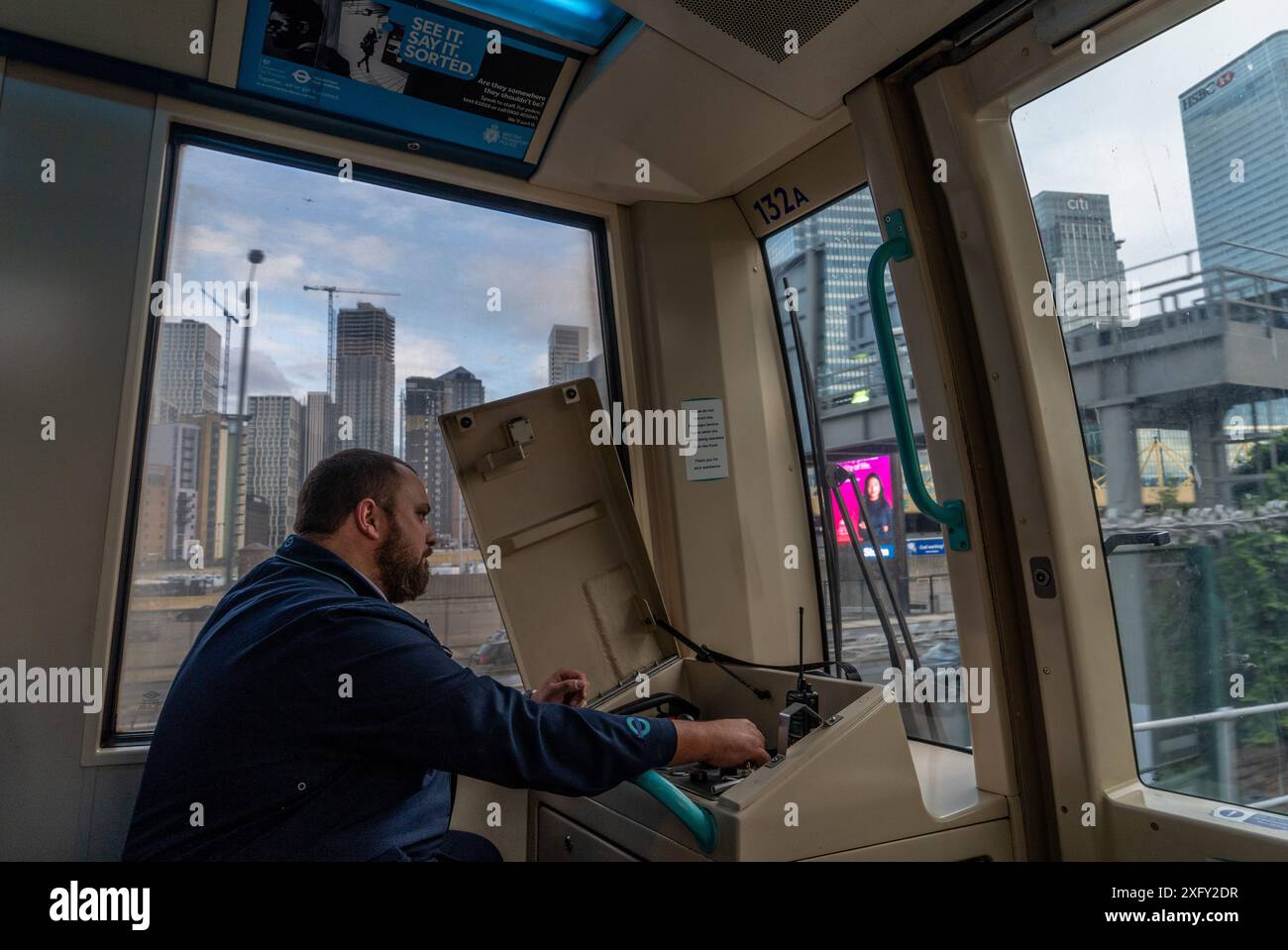 Driver in a Docklands Light Railway (DLR ) train with Canary Wharf ...