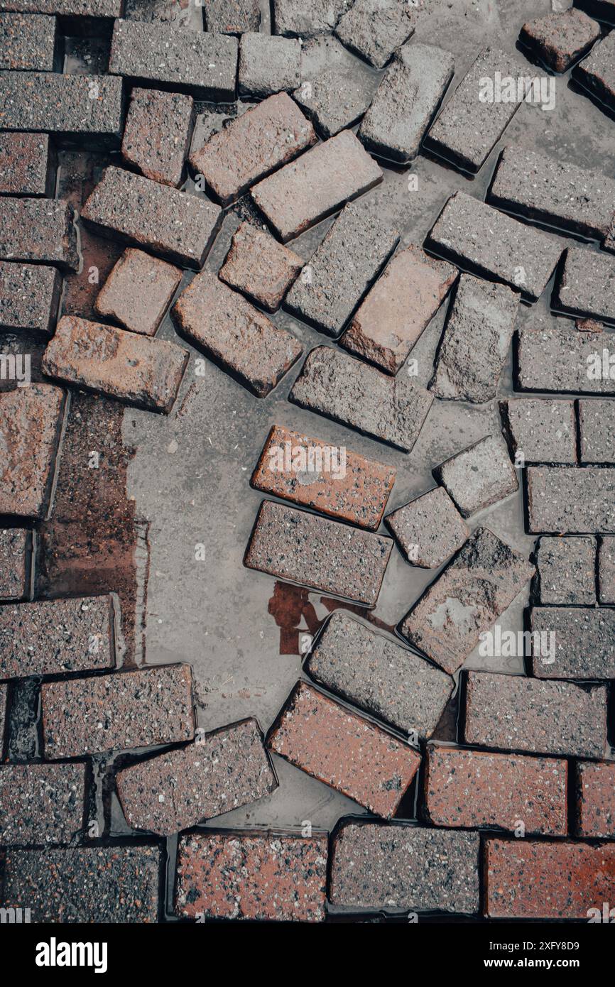 Wet pavement after rain, vertical. Broken paving stones with puddle ...