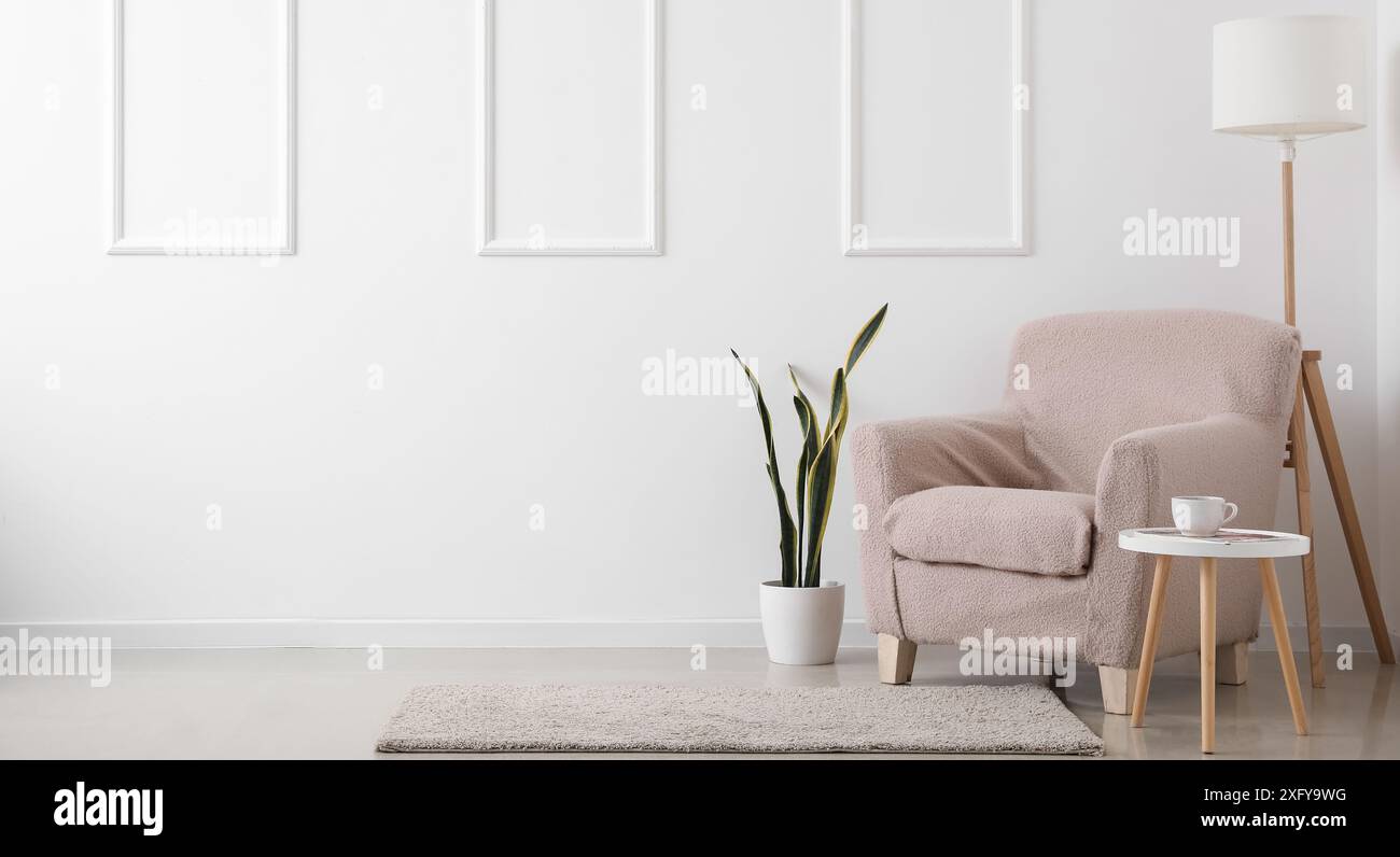 Interior of light living room with beige armchair, table and floor lamp ...