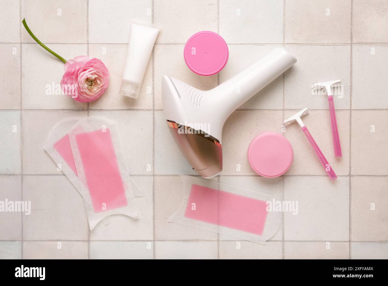 Modern photoepilator with cosmetic products, razors and wax strips on ...