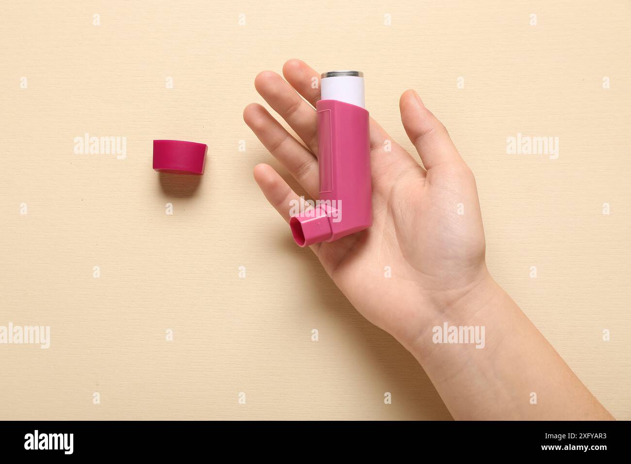 Child's hand with asthma inhaler on beige background Stock Photo - Alamy