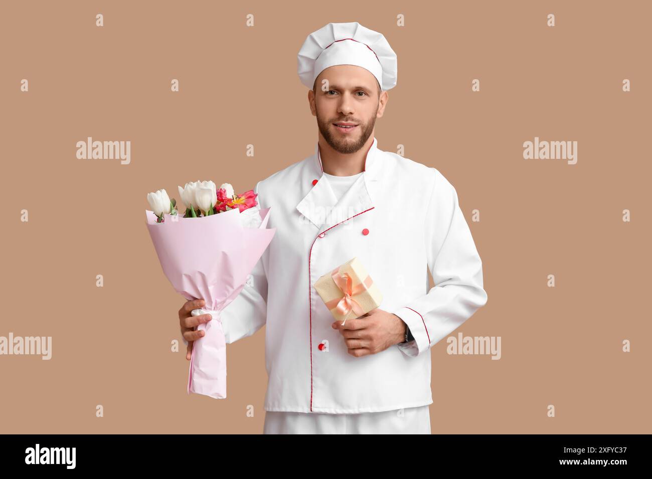 Young male chef with flowers and gift box on beige background ...