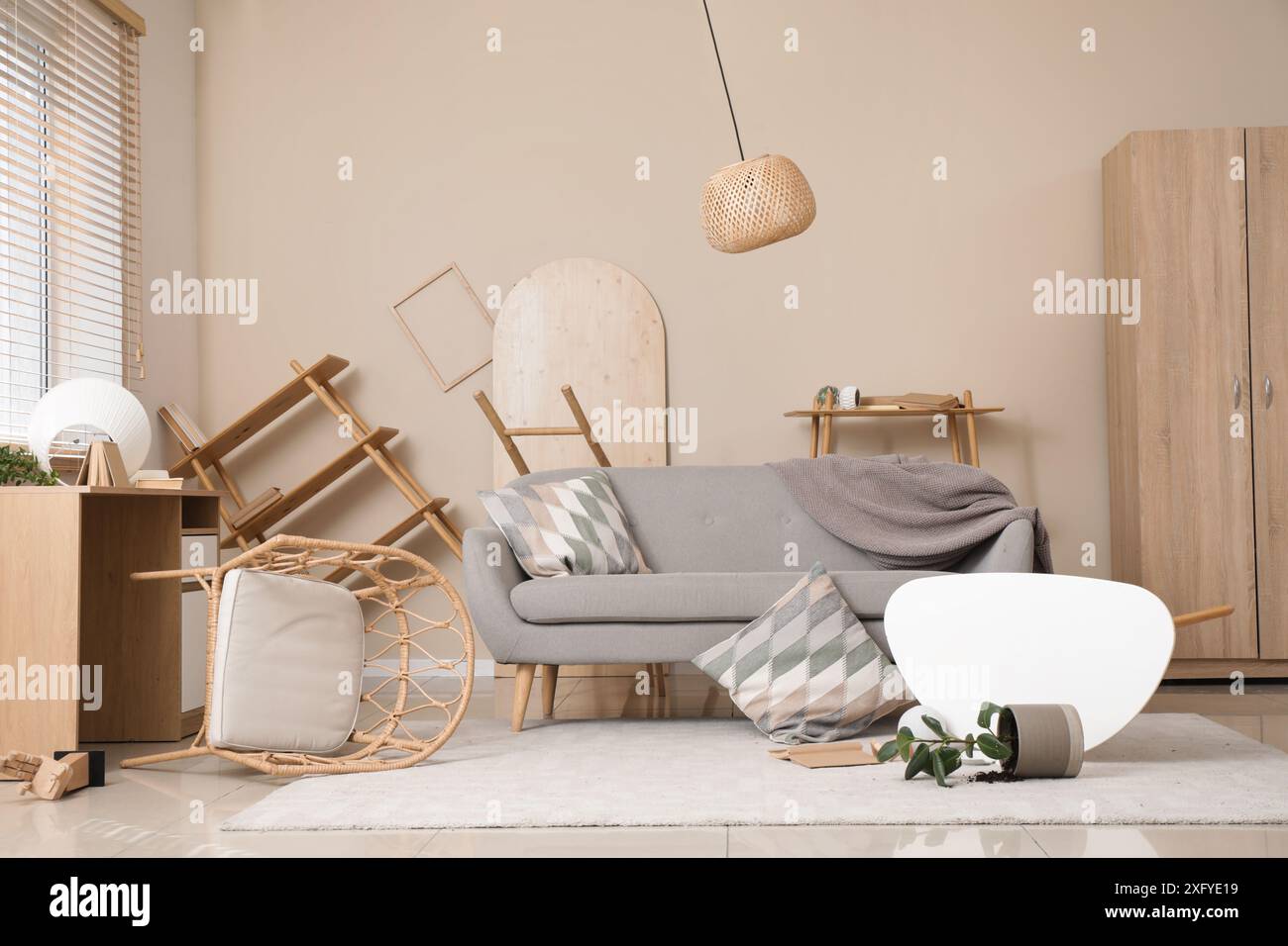 Interior of damaged living room with sofa and overturned furniture ...