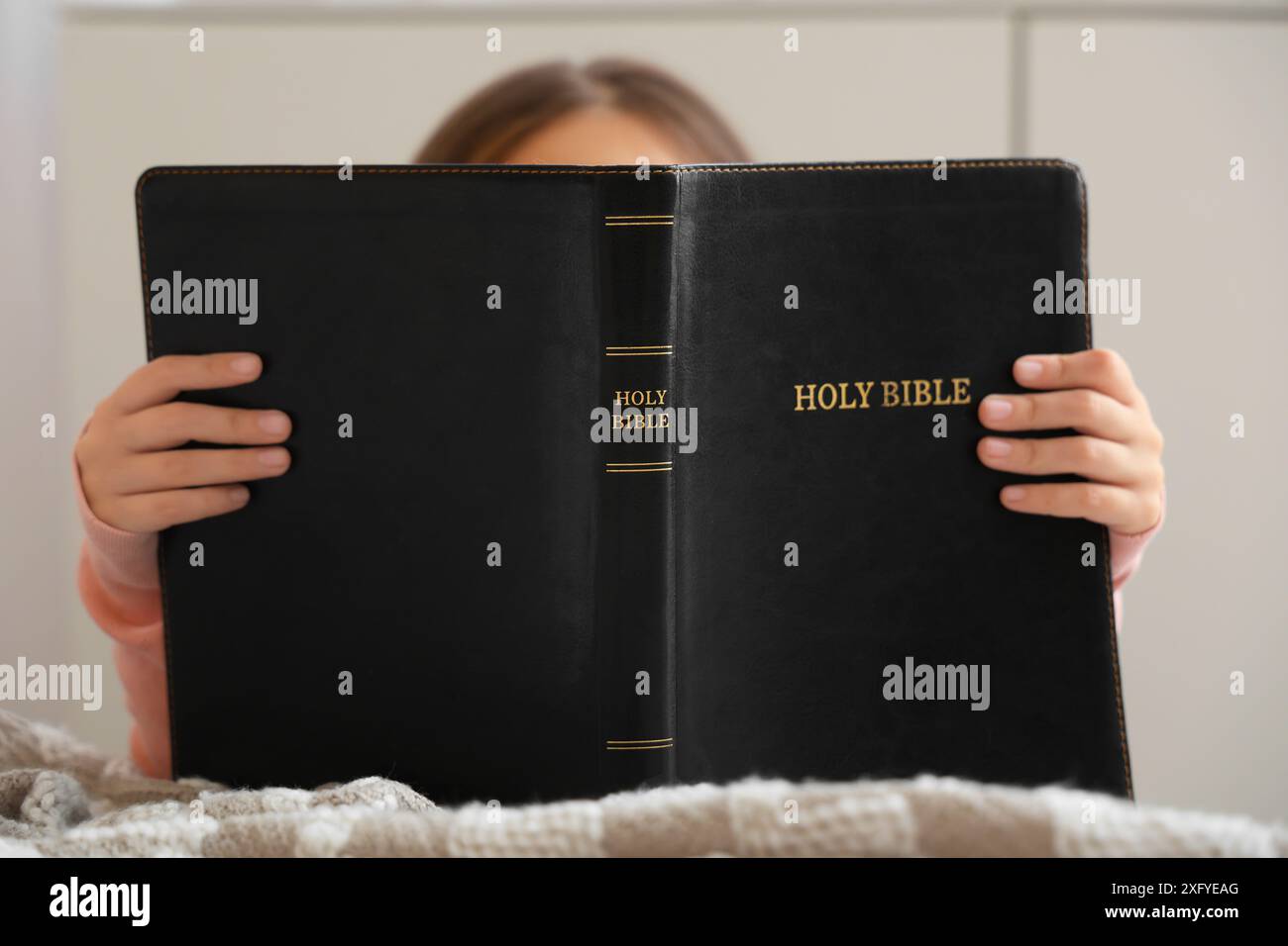 Cute little girl reading Bible at home, closeup Stock Photo - Alamy