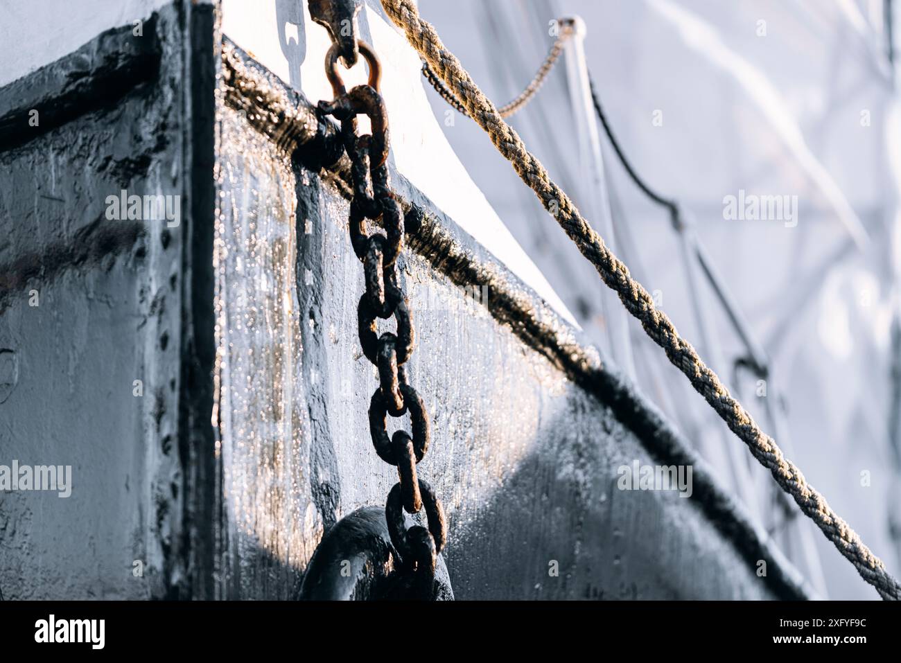 Chain of the anchor and the hull of a ship in the port of Flensburg ...