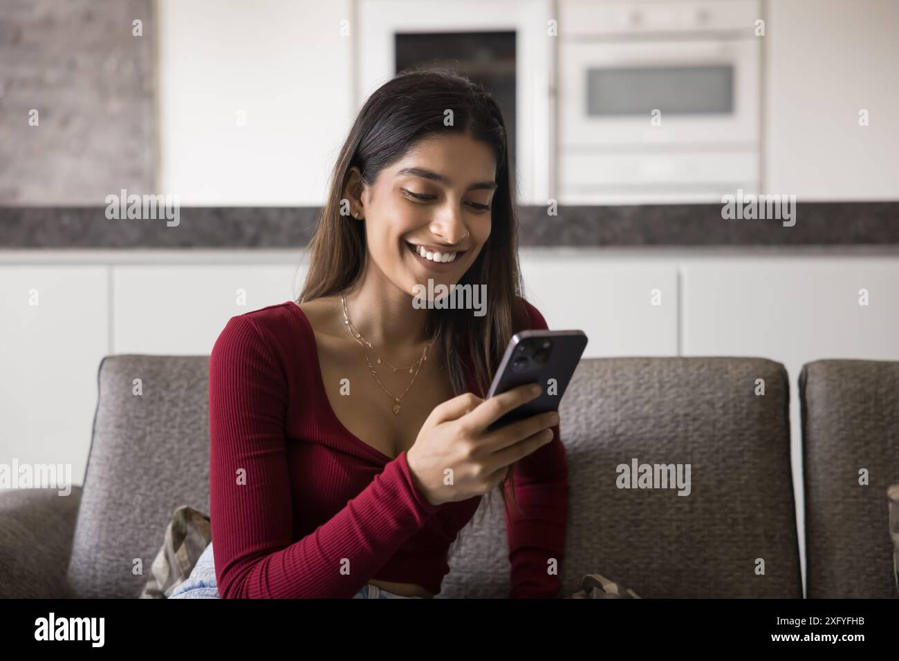Positive beautiful young Indian woman reading text message Stock Photo ...