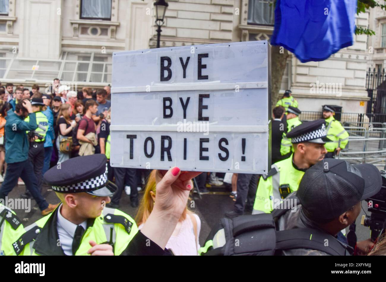 London, UK. 5th July 2024. An activist holds an anti-Tory sign. Crowds ...