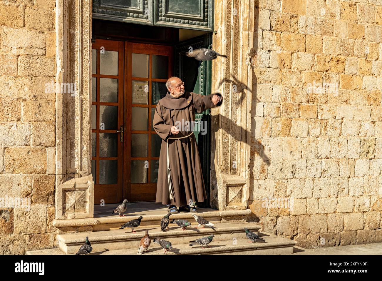 Monk feeding the pigeons hi-res stock photography and images - Alamy