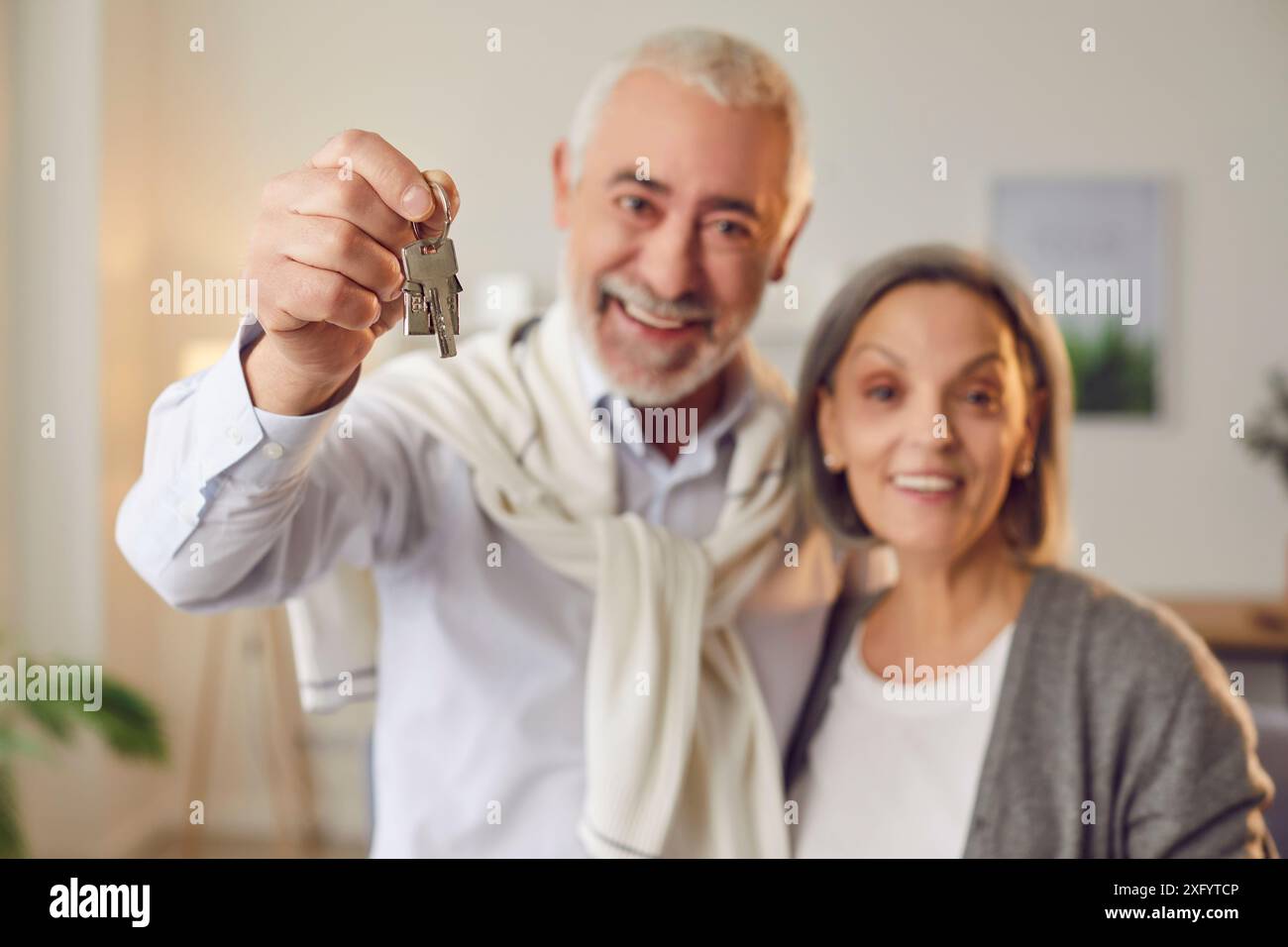 Happy elderly couple holding keys to new home fresh chapter in their ...