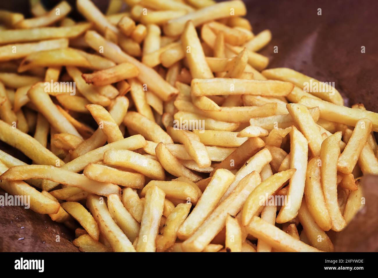 A close-up view of a large quantity of freshly cooked French fries ...