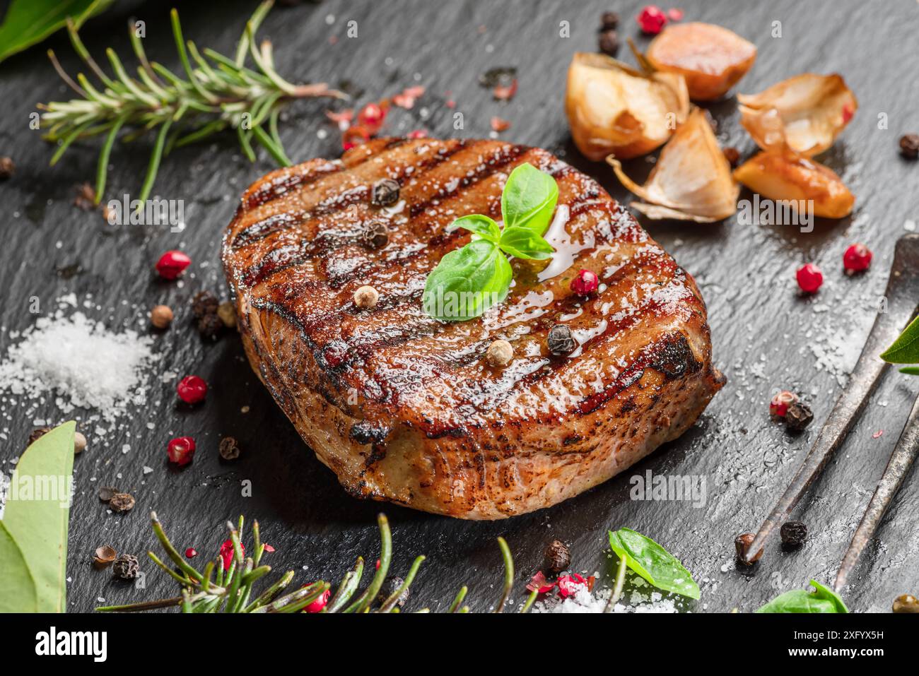 Grilled delicious ribeye steak and some seasonings and herbs on black ...