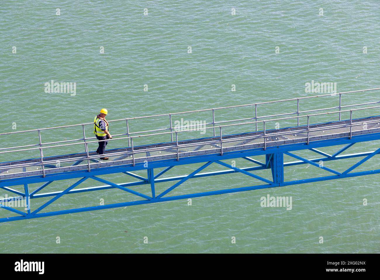 Workman on walkwak gantry over water, Portsmouth, Hampshire, England ...
