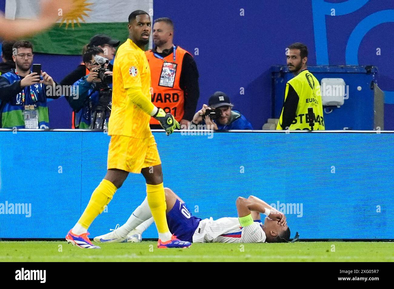 France's Kylian Mbappe holds his face after the ball hit his nose ...