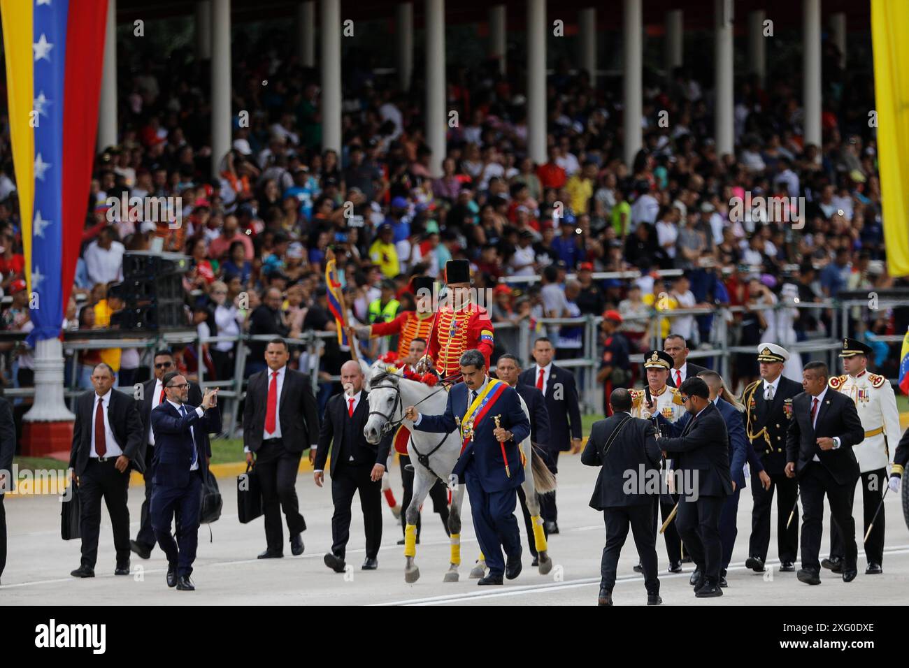 President Nicolas Maduro wearing his presidential sash, center, walks ...