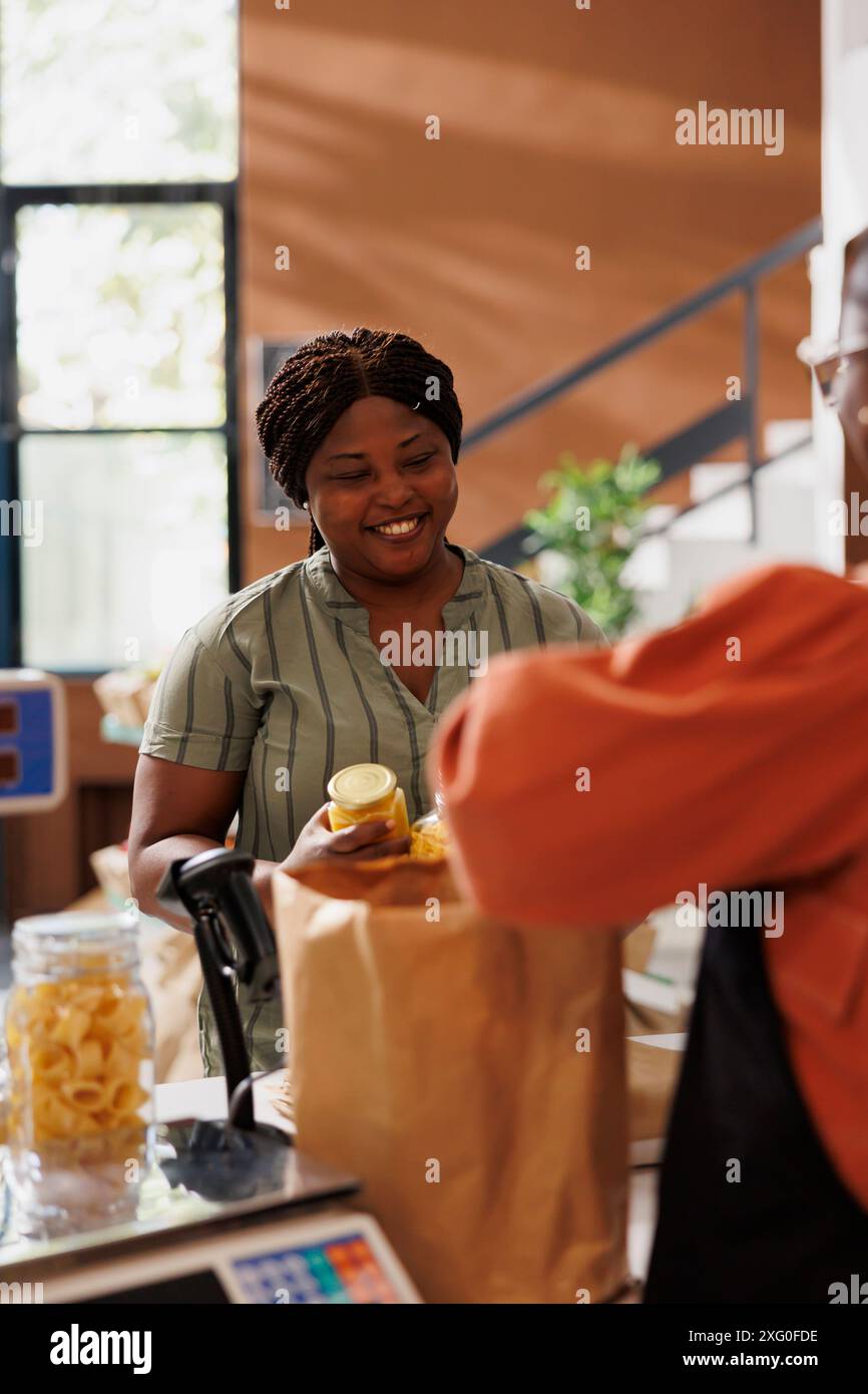 Cheerful female customer with locally grown produce at the checkout ...