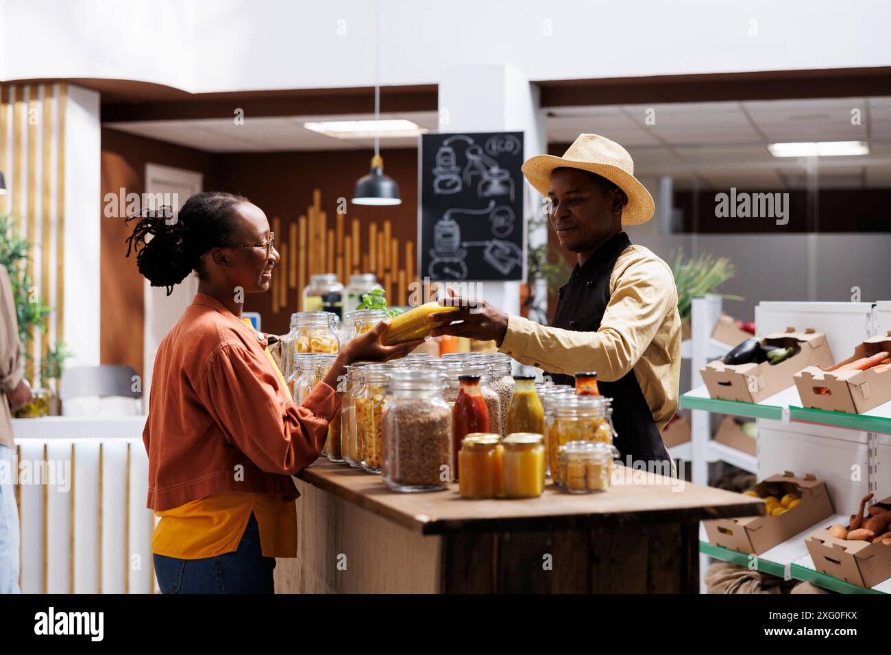 African American male shopkeeper discussing with a female customer ...