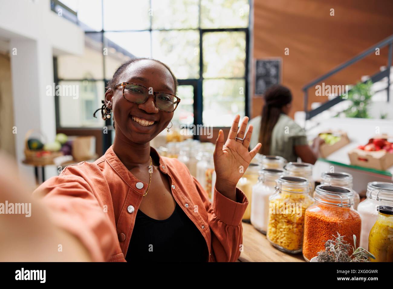 African american female influencer waving to camera, vlogging ...