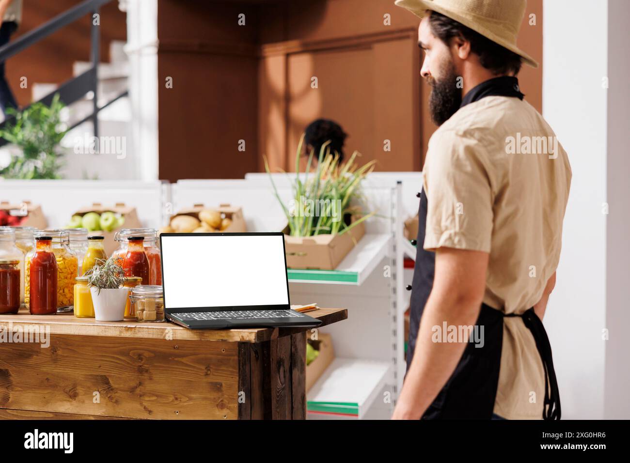 Local shop vendor looks at laptop showing isolated chromakey template ...