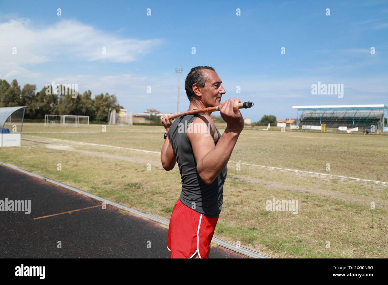 Athlete Using A Bar To Stretch Stock Photo - Alamy