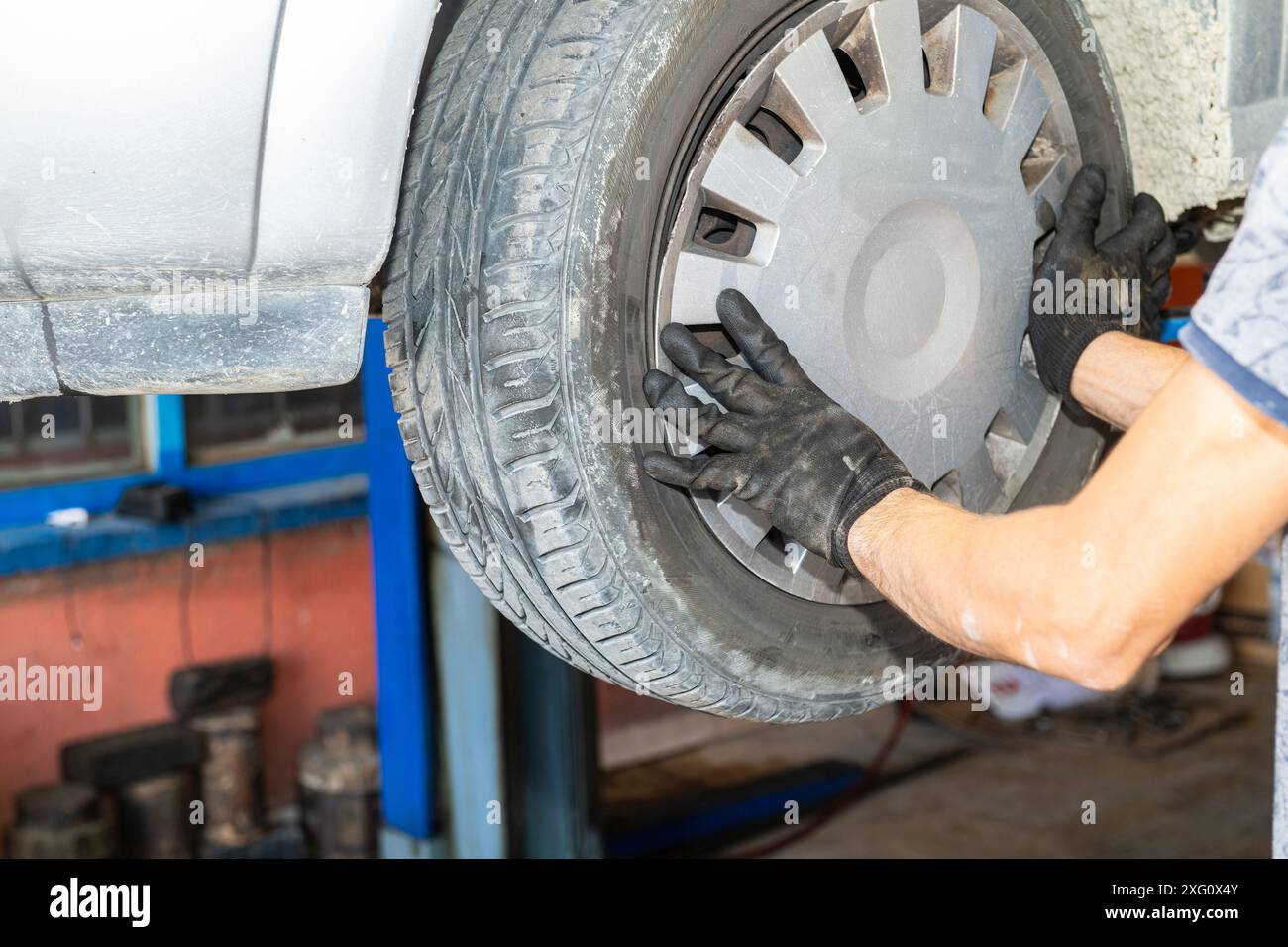 The mechanic is putting a tyre on the car Stock Photo - Alamy