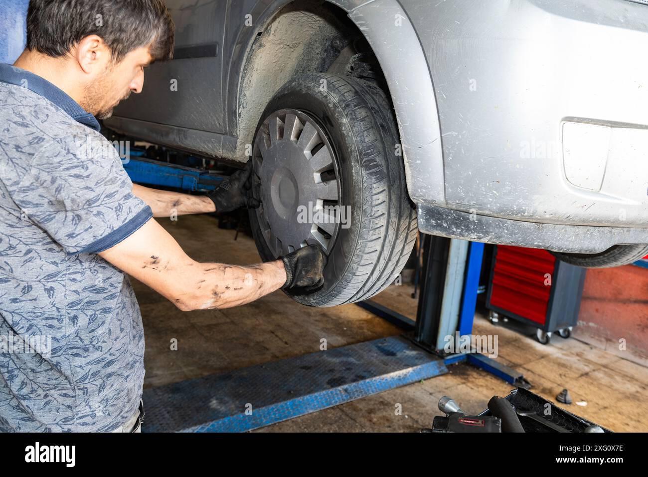 The mechanic is putting a tyre on the car Stock Photo - Alamy