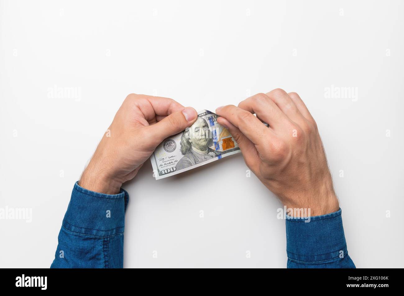 Men's hands are tearing money. Hands tearing a hundred dollar bill on a ...