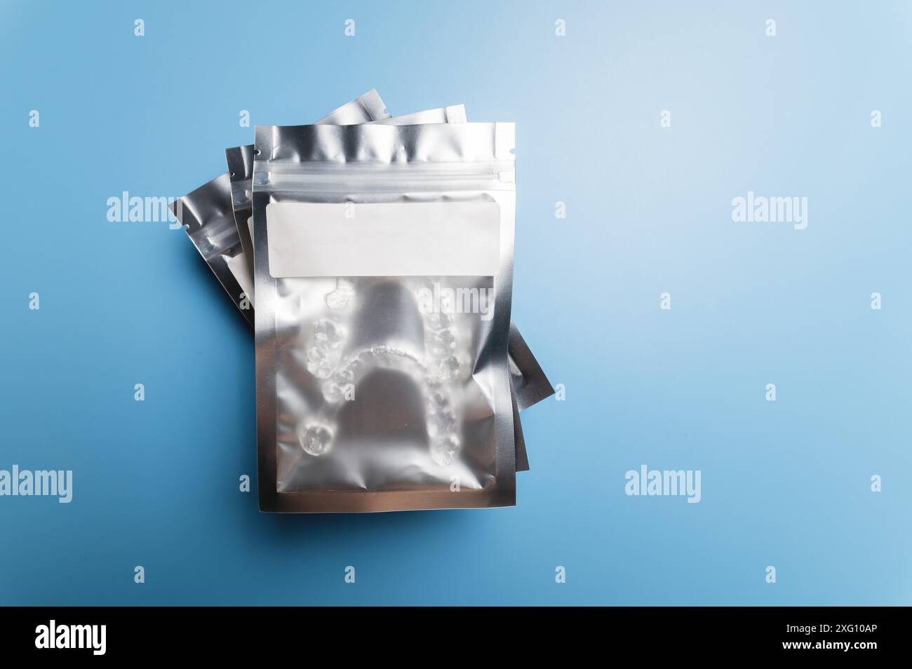 Silver plastic package body with transparent braces inside on a blue ...